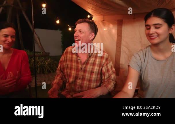 Family together celebrate anniversary in garden. Senior give gift to ...