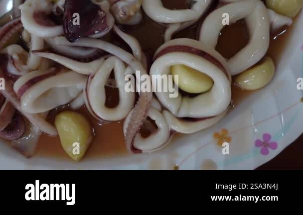 Calamari squid ring stir fry with sauce and garlic close up top view ...