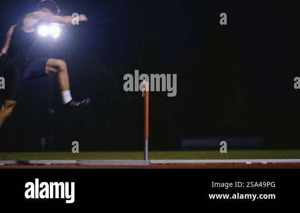 Strong Male Athlete is Running Towards an Obstacle, Hurdling, Jumping ...