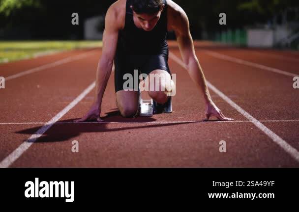 Strong Young Man Starting a Race From Track Starting Blocks Position on ...