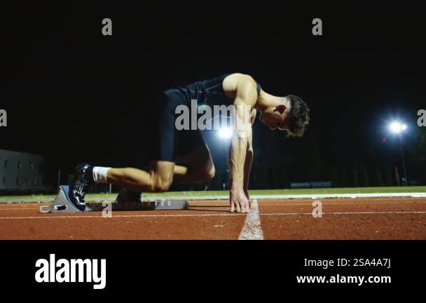 Strong Young Man Starting a Race From Track Starting Blocks Position on ...