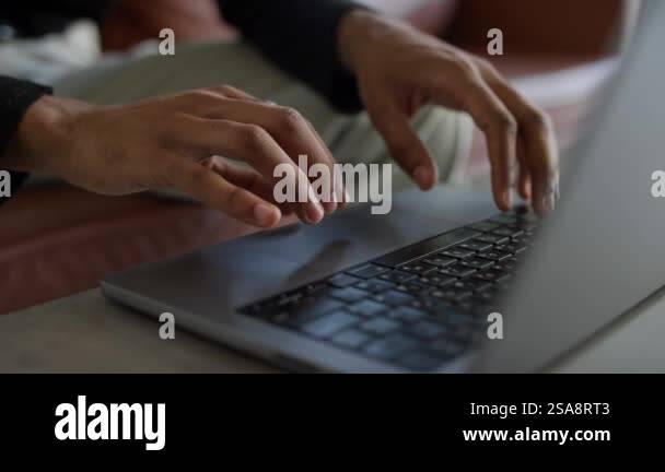 Close-up view of hands typing on a laptop keyboard, focusing on ...