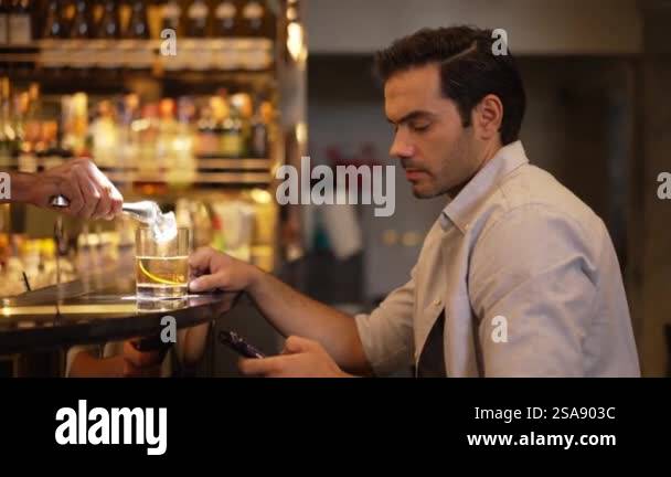 Smart man drinking cocktail in Old fashioned waiting friends or couple ...