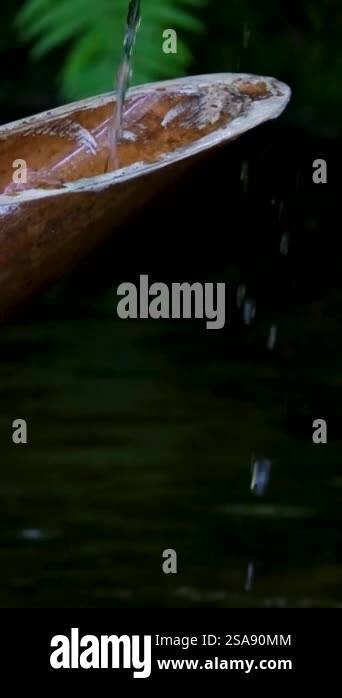 leaking water stream from bamboo, wellness concept. Filmed on very high ...