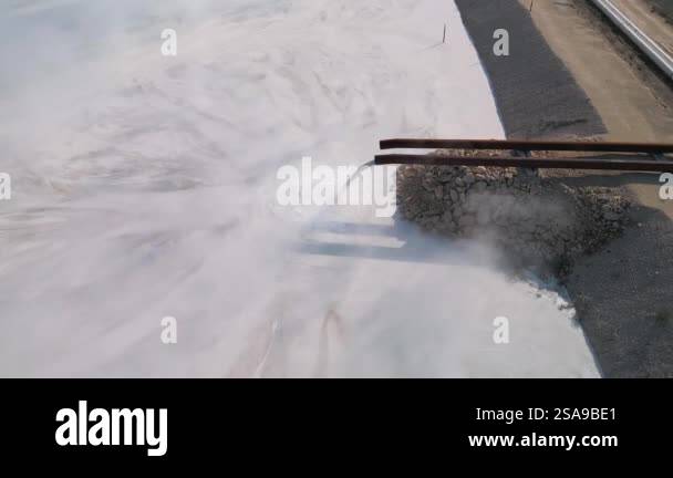 A tailings lake of a cement factory with pipes visibly discharging ...