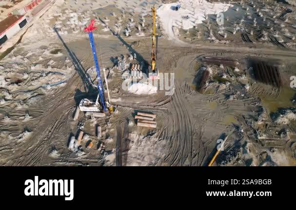 A construction site with heavy machinery drilling and preparing ...