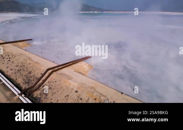 A tailings lake of a cement factory with pipes visibly discharging ...