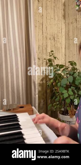 A young music teacher guides a child in learning to play the musical ...