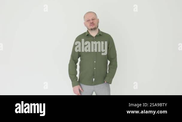 Man stands in front of a plain white wall and gestures, demonstrating ...