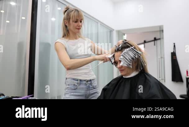 Hairdresser does highlights on client in a beauty salon. Hairdresser ...