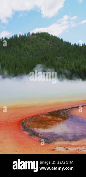 A stunning landscape of the Grand Prismatic Spring, showcasing vibrant colors and mist ...