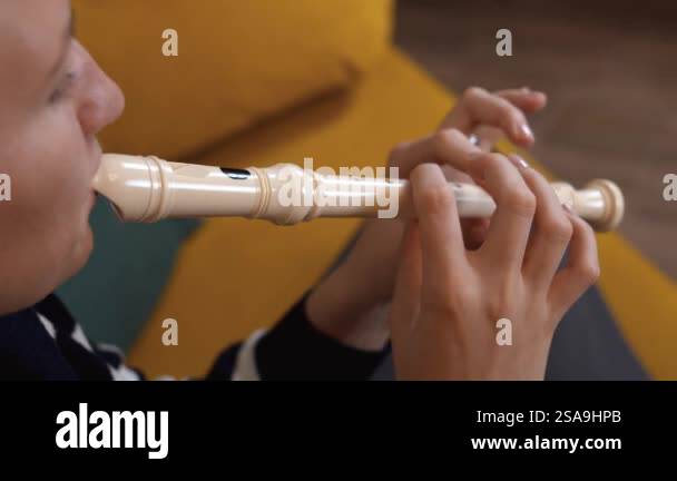 Young musician playing a recorder flute, demonstrating proper finger ...