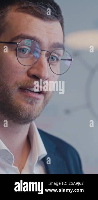 Vertical Screen: Young professional in a business setting giving a ...