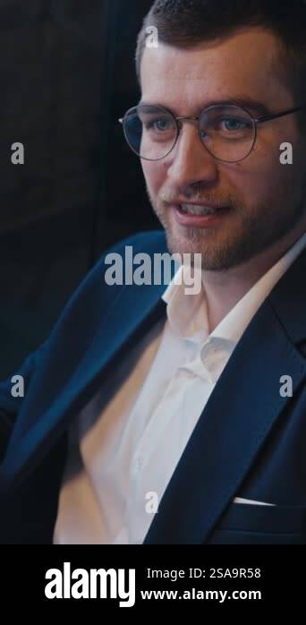 Vertical Screen: Confident businessman in glasses gesturing and ...