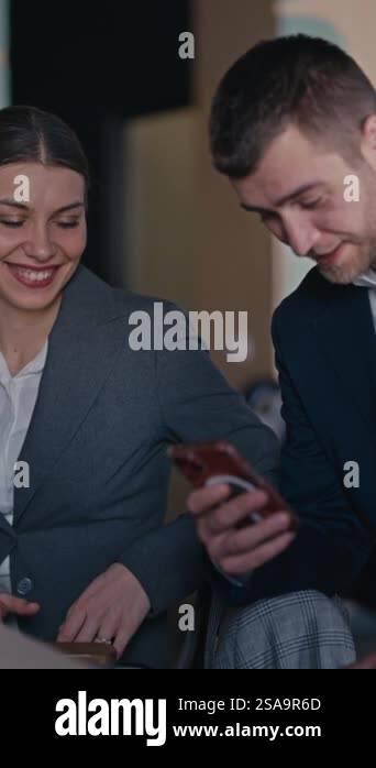 Vertical Screen: Colleagues in formal business attire enjoying a ...