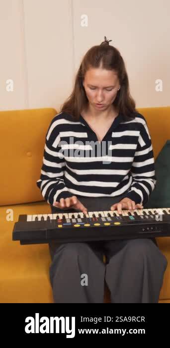 Female musician playing electronic keyboard synthesizer creates ...