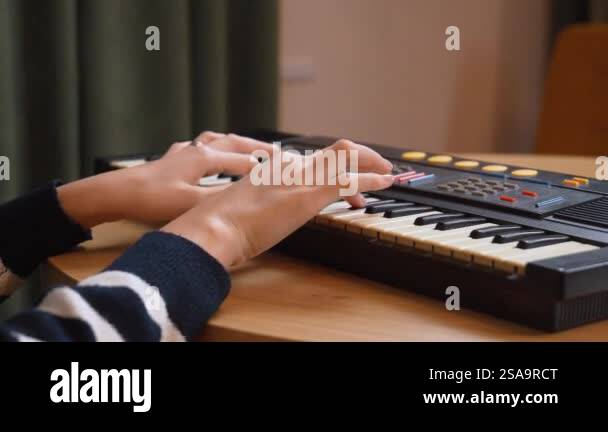 Female musician practicing new song on electronic keyboard, fingers ...