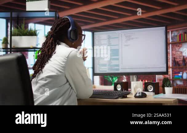 Jolly engineer in home office working on computer, dancing at desk in ...