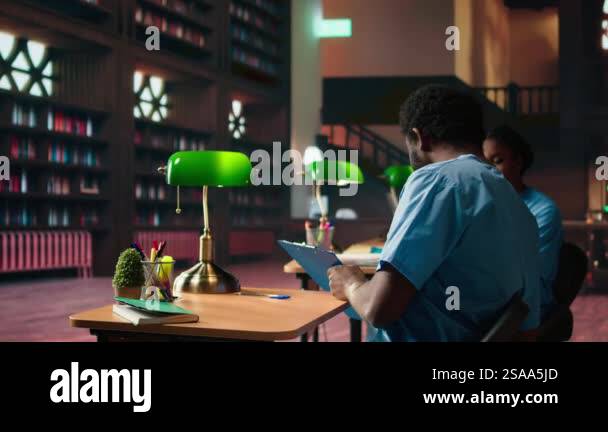 Future nurses studying anatomy class notes in a university library ...