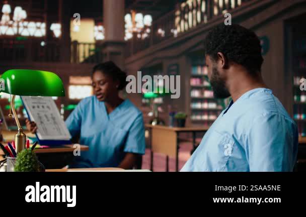 African American pupils studying together for med school exams, man and ...