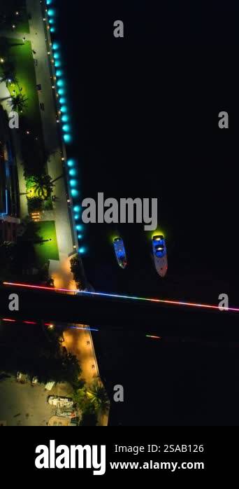 Bigger and smaller yachts move by the dark river at night. Drone ...
