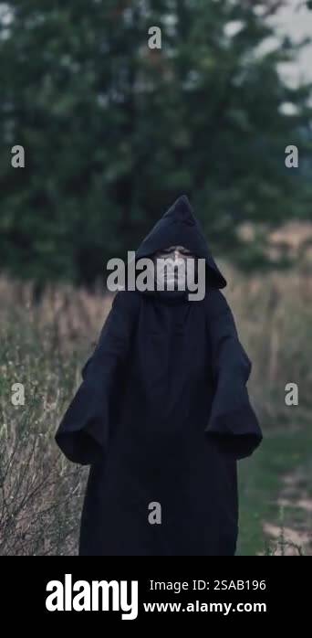 Portrait of scary death in black. Spooky figure in dark mantle with ...