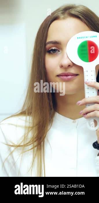 Young woman checking eyesight. Pretty girl doing vision test with one ...