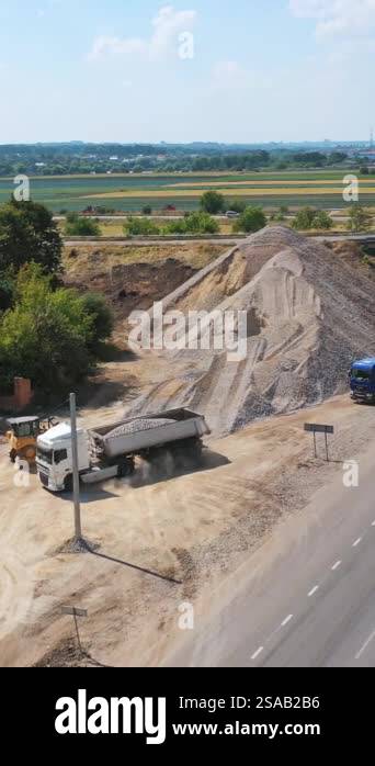 Heavy machinery with stones. New road with moving transport near the ...