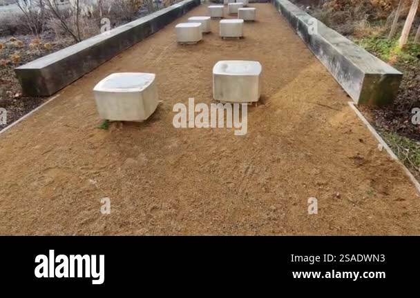 Concrete blocks with both sides shaped like cubes are seats in the park ...