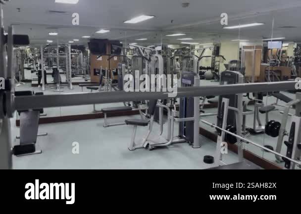This image shows a gym with various exercise machines and weights, it ...
