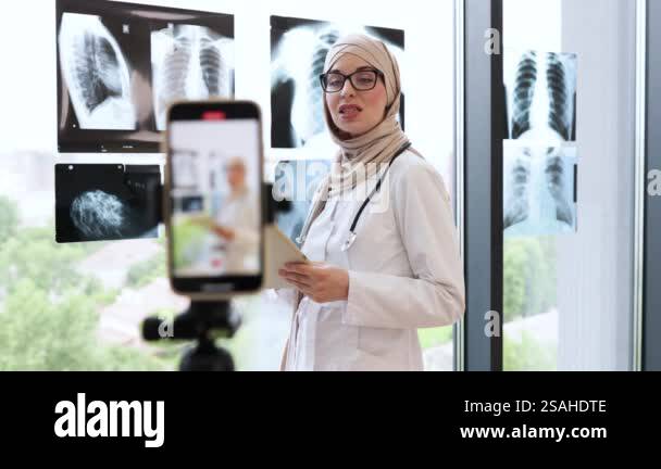 Muslim female doctor recording video lesson using x-ray scans. Young ...