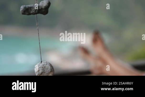 Stones hanging on strings with a blurred background of a tourist ...