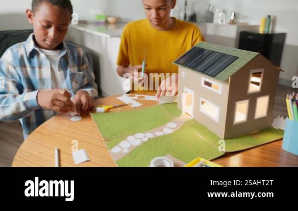 Camera transitions from close-up of solar-powered cardboard house model ...