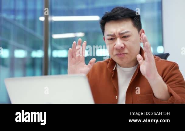 Angry asian businessman arguing talking on video call on laptop sitting ...