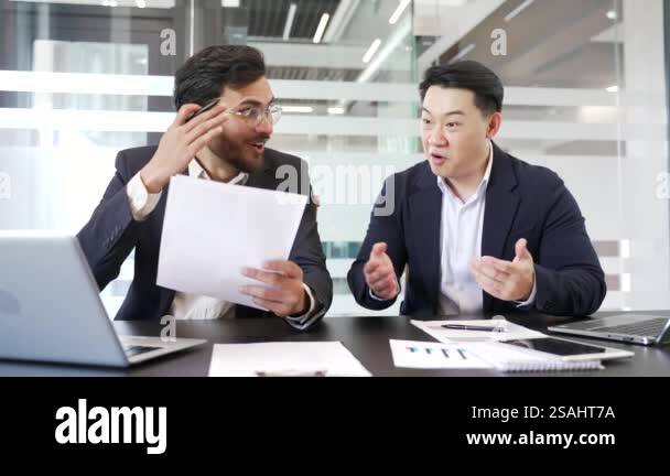 Two excited businessmen celebrate successful results in office setting ...