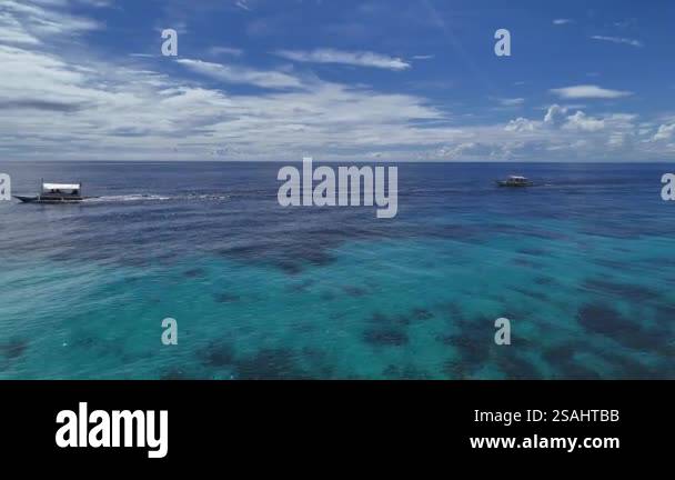 A serene aerial view of a traditional Filipino boat gliding across ...