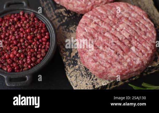 Fresh raw ground beef burger patty with salt and spices on textured ...