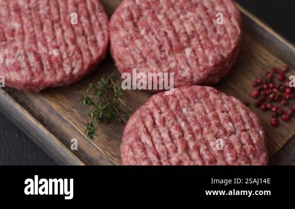 Fresh raw ground beef burger patty with salt and spices on textured ...