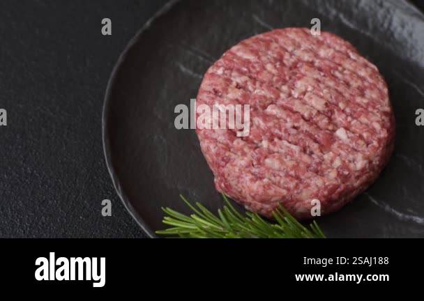 Fresh raw ground beef burger patty with salt and spices on textured ...