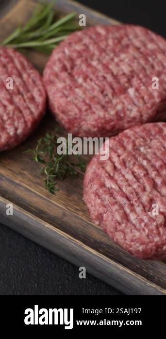 Fresh raw ground beef burger patty with salt and spices on textured ...