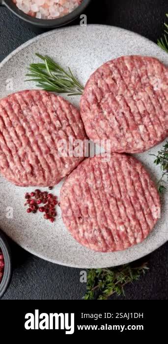 Fresh raw ground beef burger patty with salt and spices on textured ...