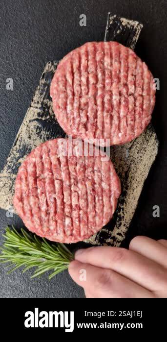 Fresh raw ground beef burger patty with salt and spices on textured ...