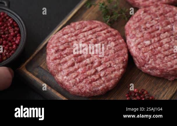 Fresh raw ground beef burger patty with salt and spices on textured concrete background Stock ...