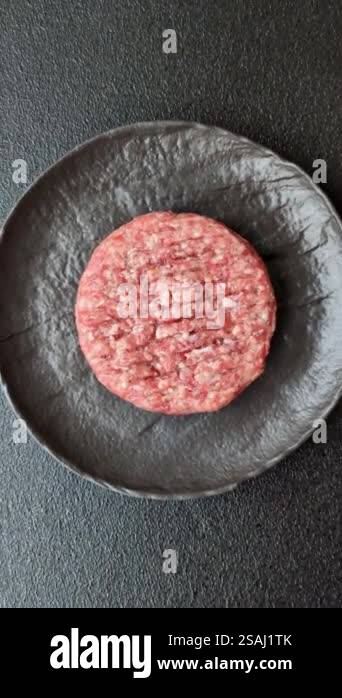 Fresh raw ground beef burger patty with salt and spices on textured ...