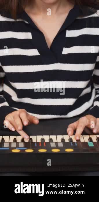 Female musician practises playing keyboard by recording intricate ...