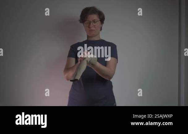 Woman puts on compression sleeve on arm to support vein health and ...