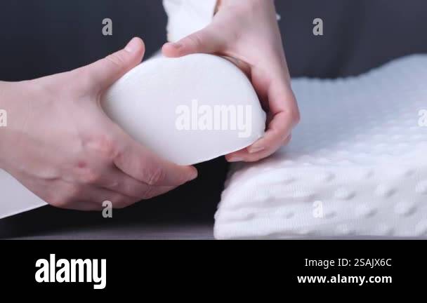 Woman squeezing a polyurethane pillow, demonstrating its memory foam ...