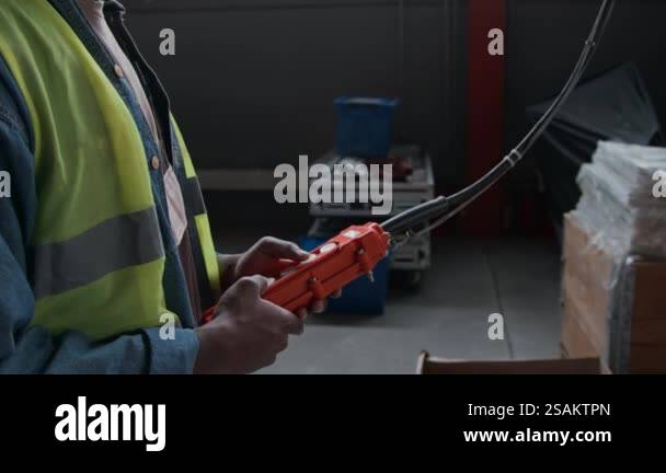 Medium arc slowmo shot of African American male operator in overalls ...