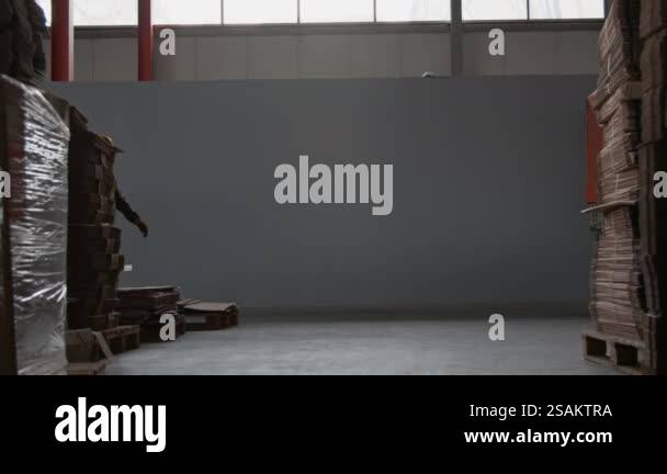 Wide lockdown shot of male factory employee in uniform, yellow ...