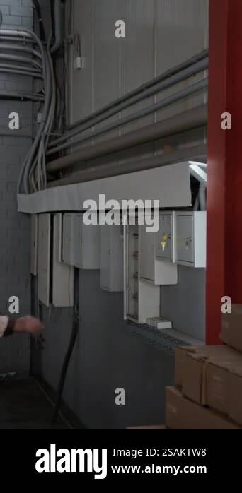 Medium full vertical shot of Asian male factory supervisor in yellow ...